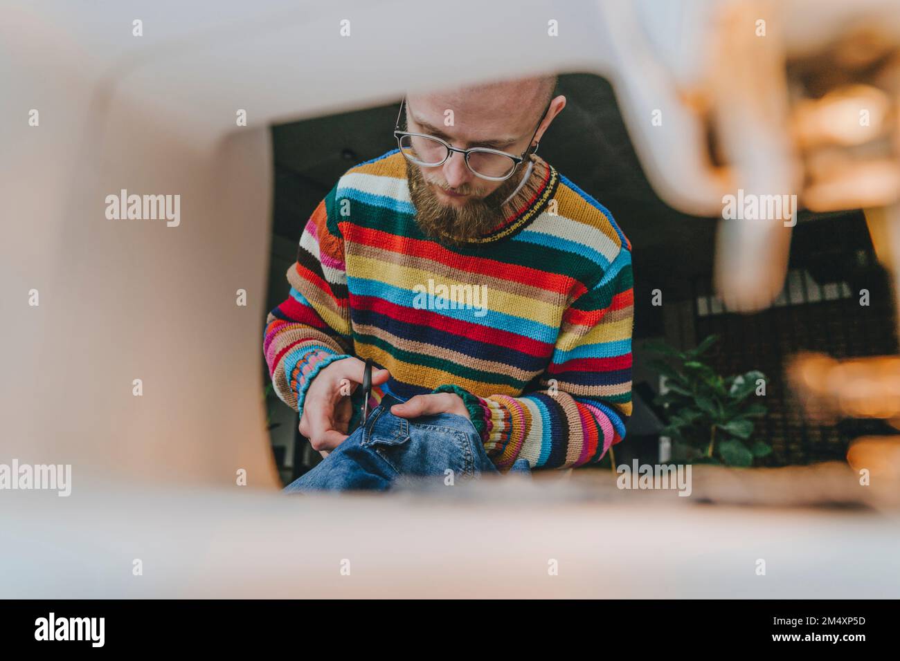 Fashion designer cutting denim fabric in workshop Stock Photo - Alamy