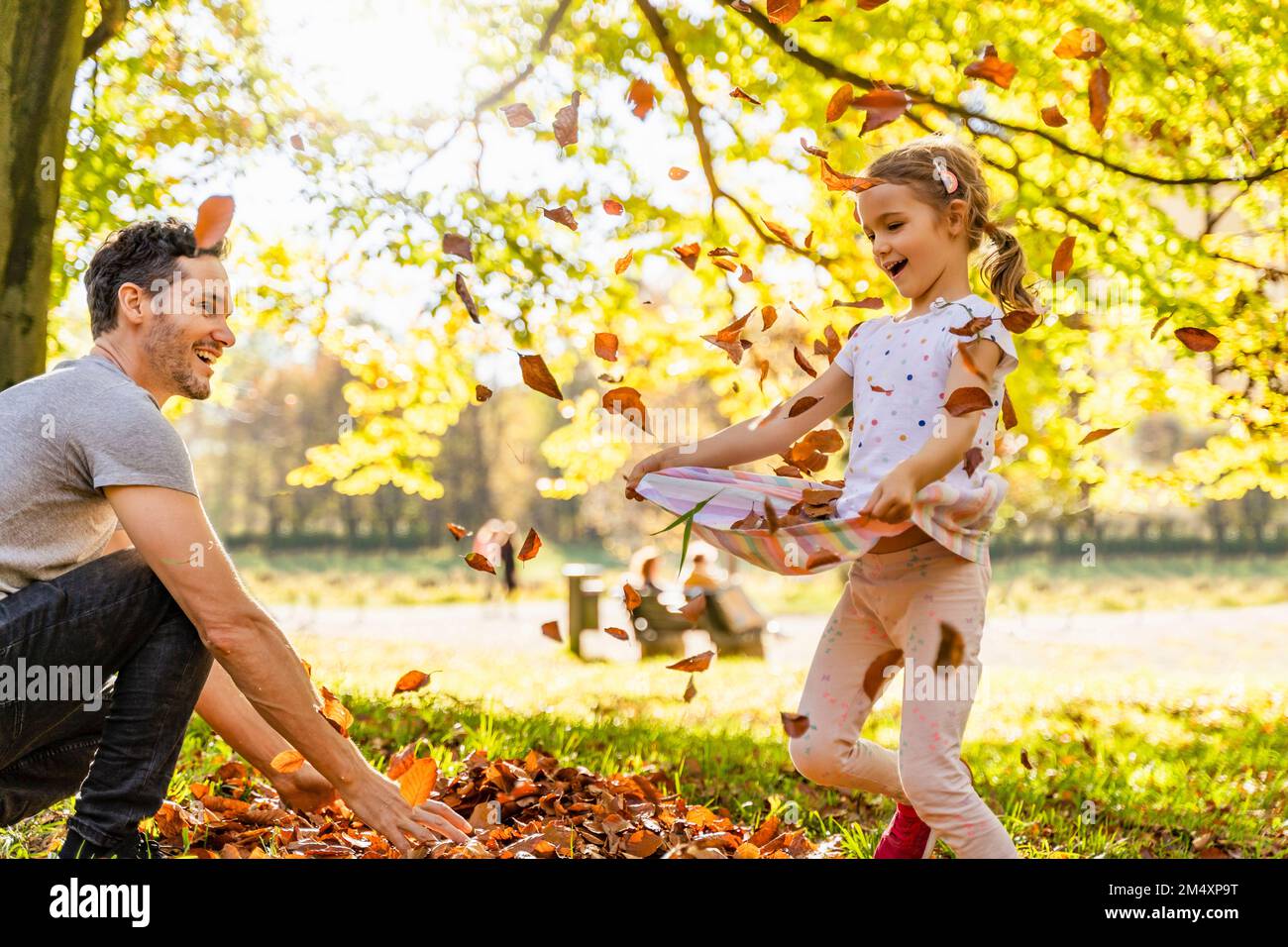 Happy father and daughter playing with autumn leaves in park Stock ...