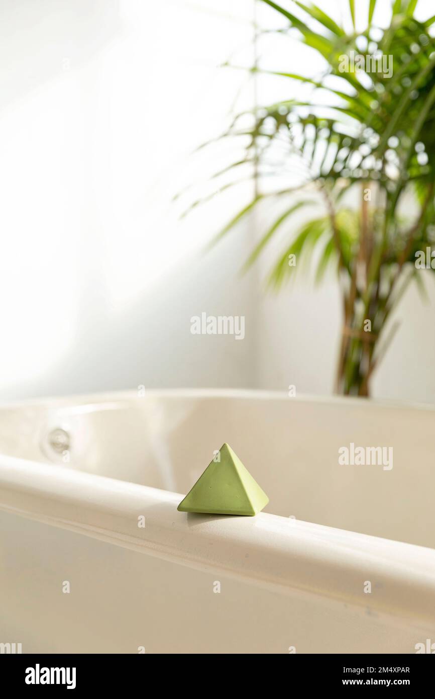 Single pyramid shaped toy block lying on bathtub rim Stock Photo - Alamy