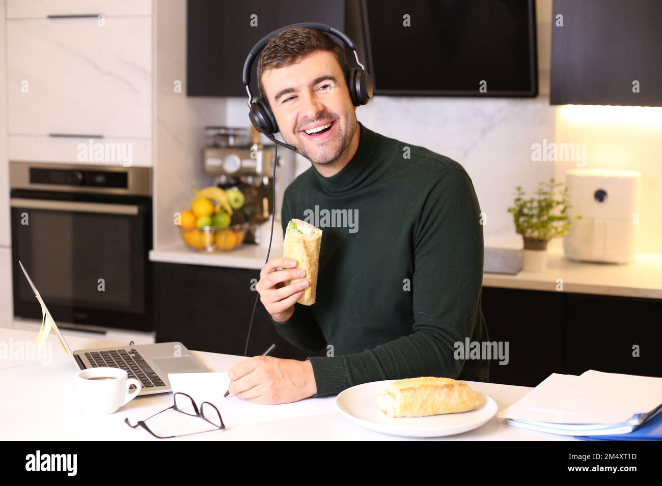 Busy man eating a sandwich while on conference call Stock Photo - Alamy