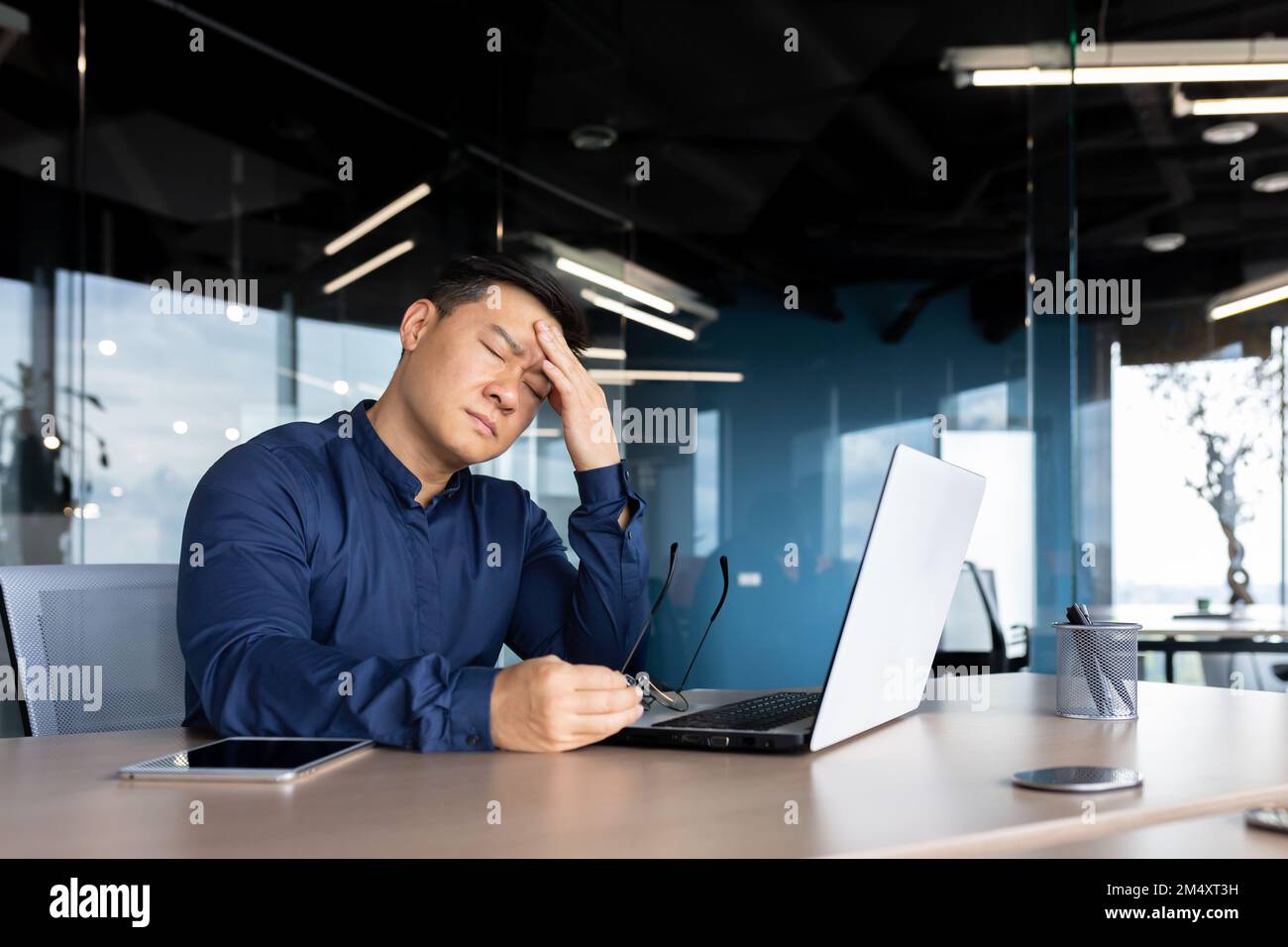 A Young Asian Man An Office Worker Feels A Strong Headache Migraine