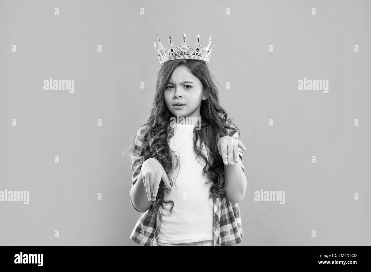 arrogant kid with curly hair in princess crown on blue background ...