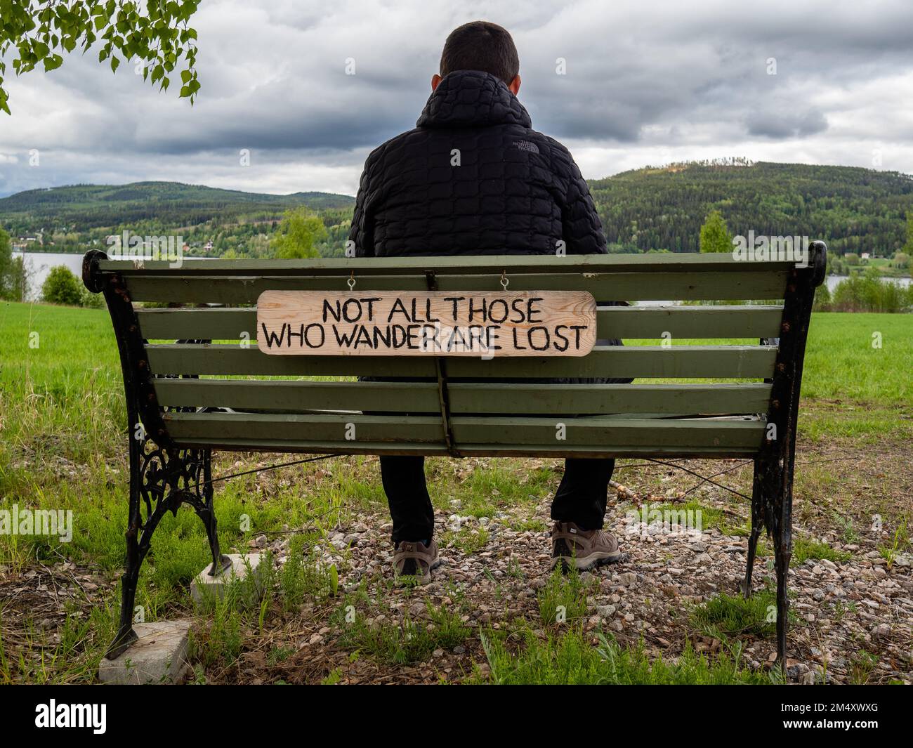 A pilgrim is taking a break on a bench with a wise sentence written on ...