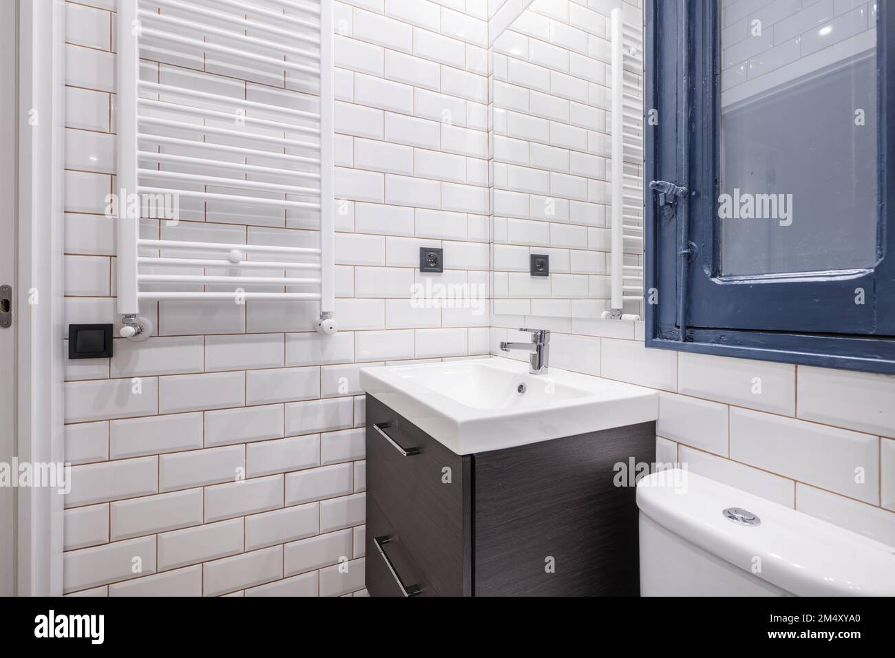 Small bathroom with a white porcelain sink on a dark wood cabinet, a ...