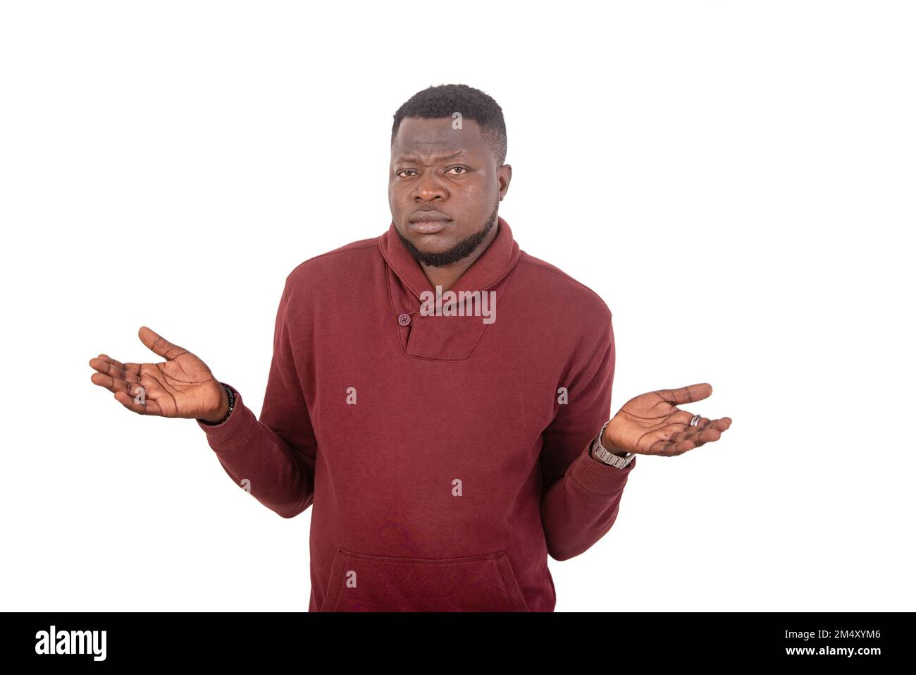 portrait of a handsome confused young man shrugging his shoulders and ...