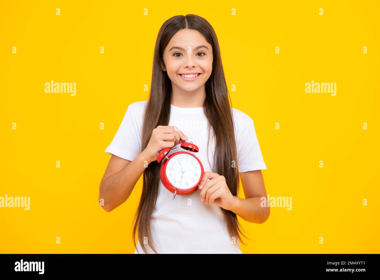 Teen student girl hold clock isolated on yellow background. Time to ...
