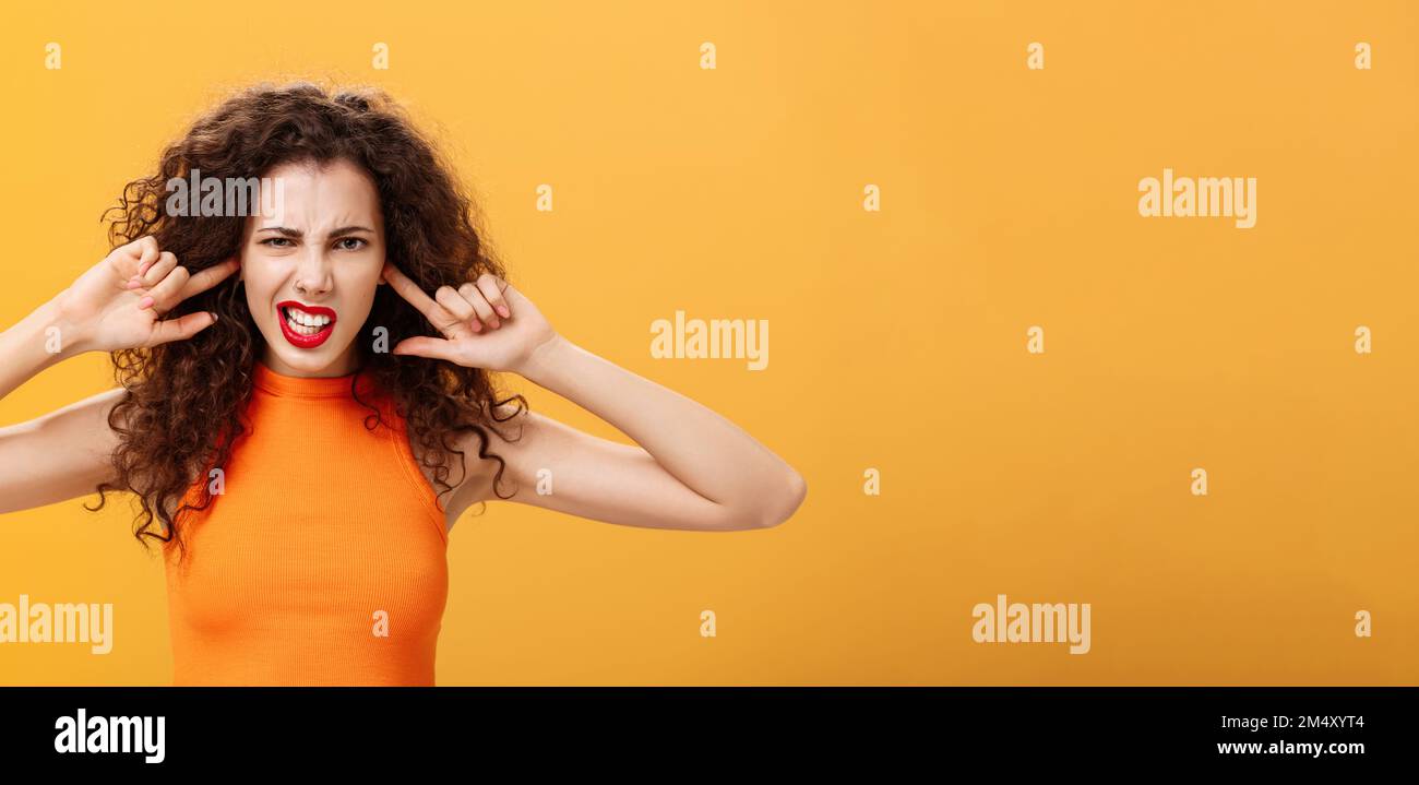 Waist-up shot of irritated bothered stylish woman with curly hair and ...