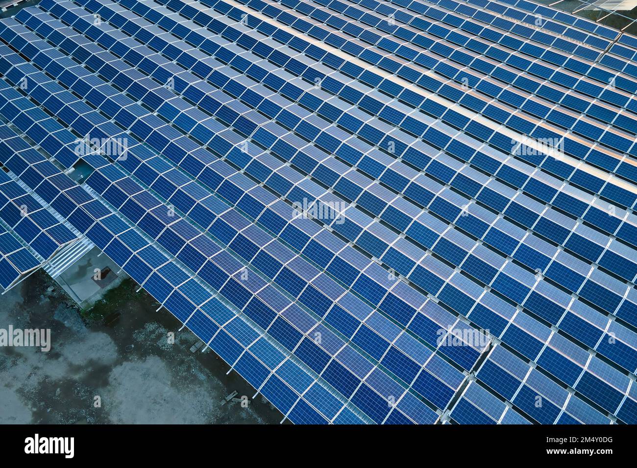 Aerial view of blue photovoltaic solar panels mounted on industrial ...
