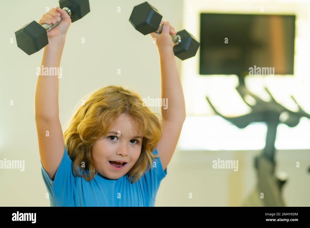 Child workout kid in gym. Cute little boy doing exercises with ...