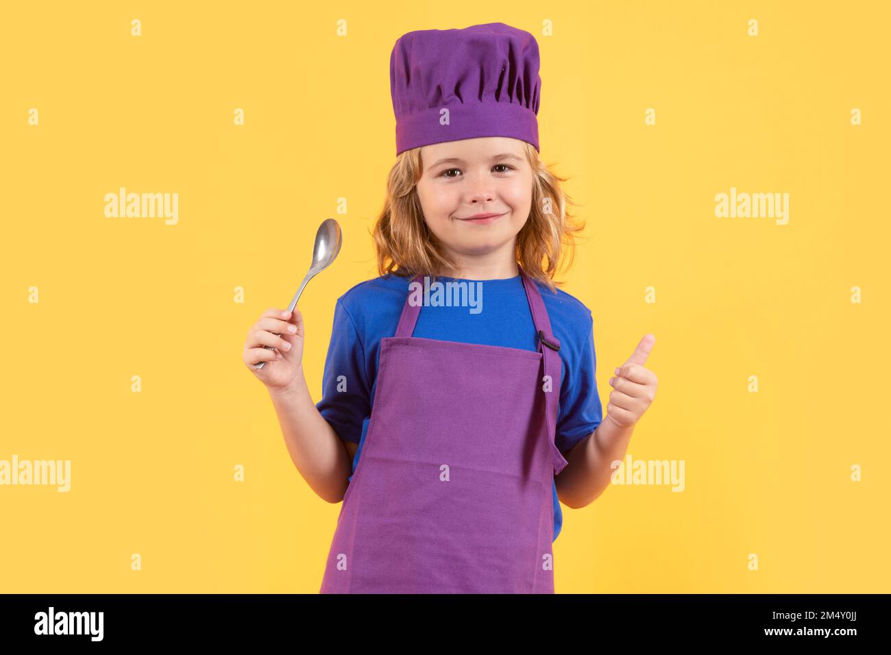 Funny kid chef cook with spoon, studio portrait. Kid in cooker uniform ...