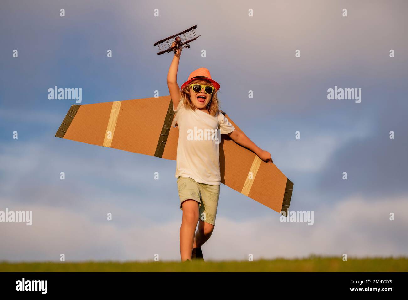 Dream of flying. Little children with toy airplane in a field at sunset ...