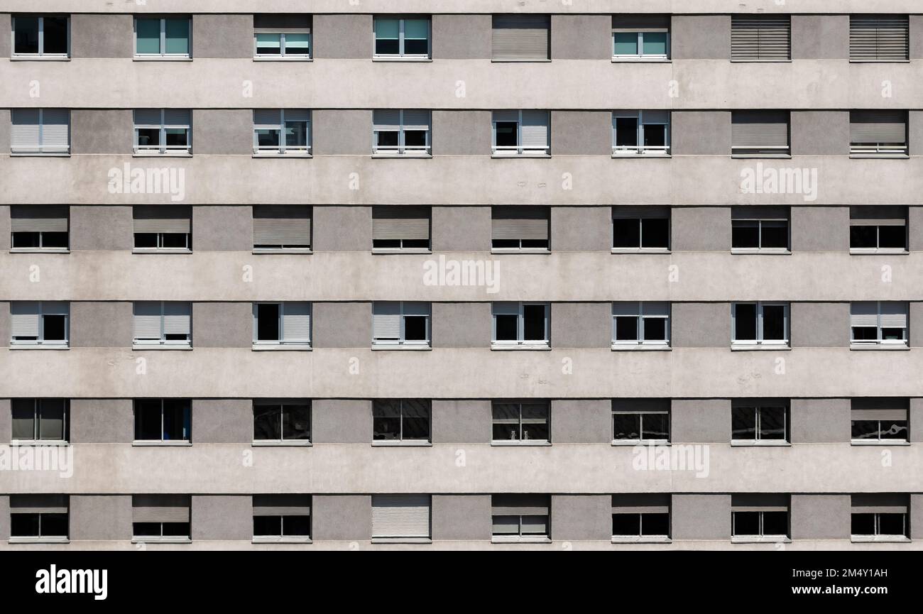 Building facade in gray tones with a geometric pattern of windows with ...