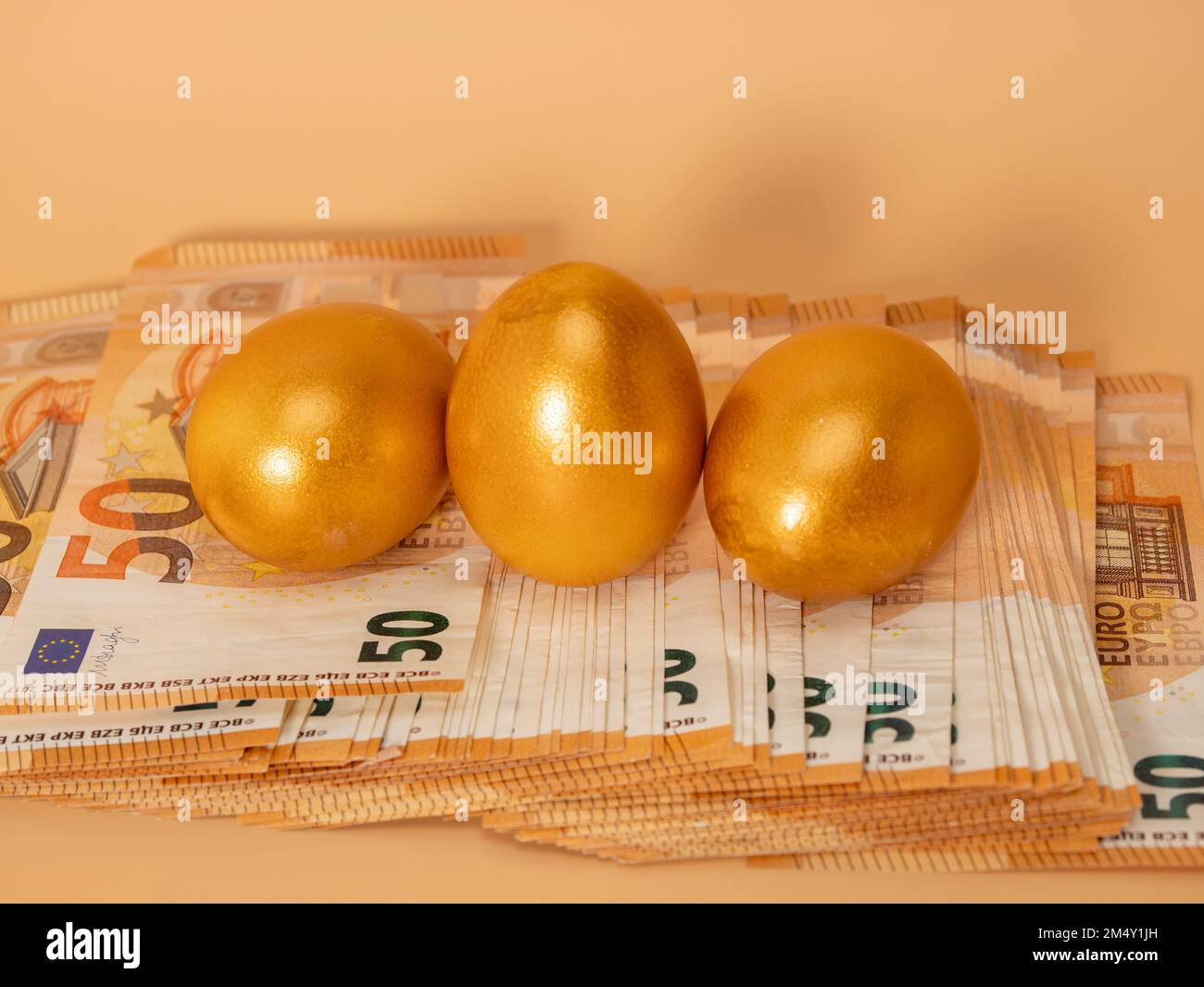 Golden eggs on money. Golden chicken eggs and euro banknotes. Wealth ...