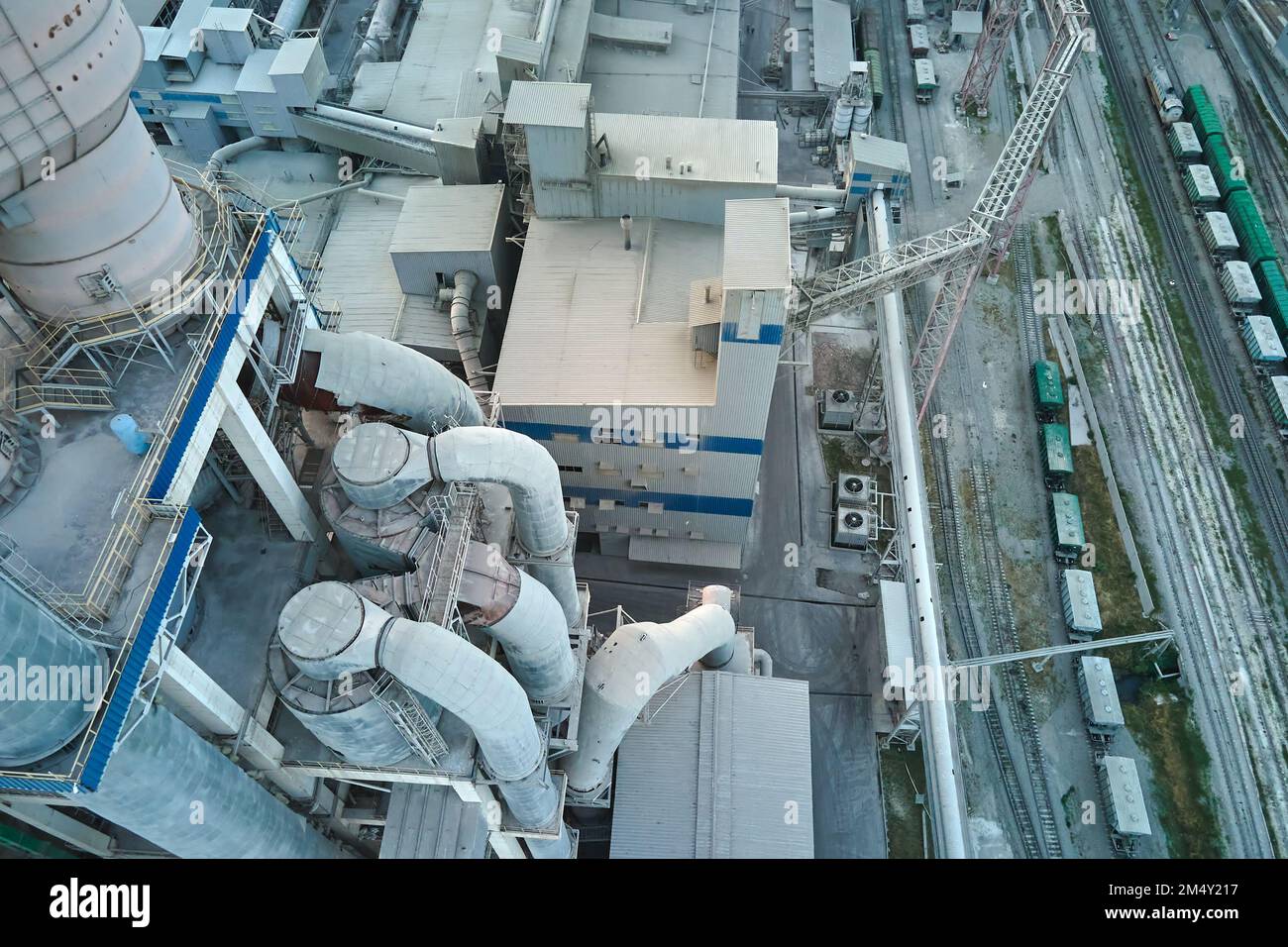 Cement plant with high factory structure and tower cranes at industrial ...