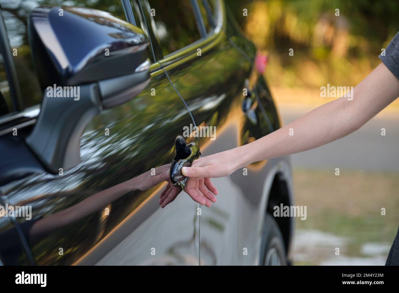 Closeup of driver hand opening car front door with touch ID finger ...