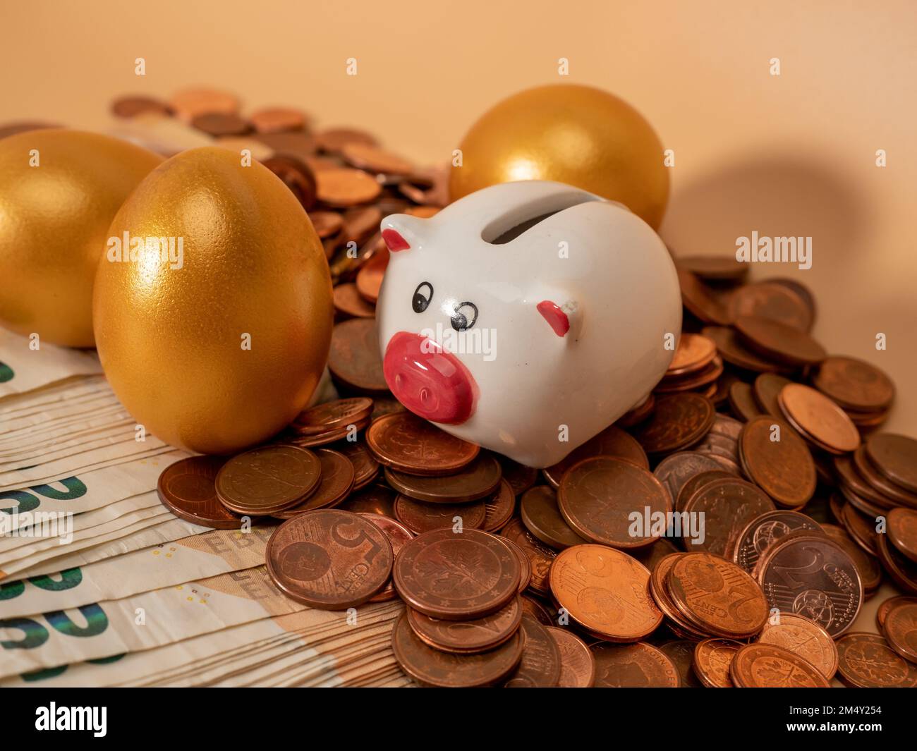 Golden eggs and piggy bank on money. Golden chicken eggs on euro ...