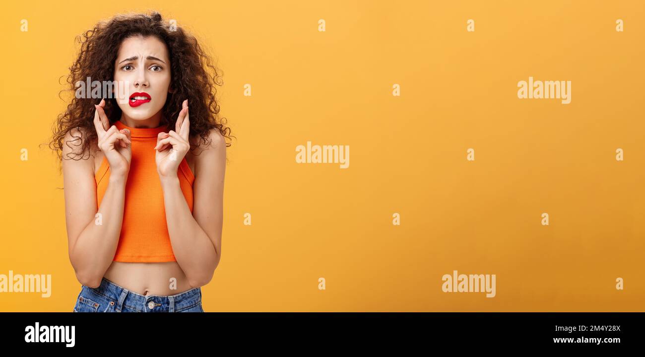 Worried and anxious silly caucasian female with curly hair in red ...