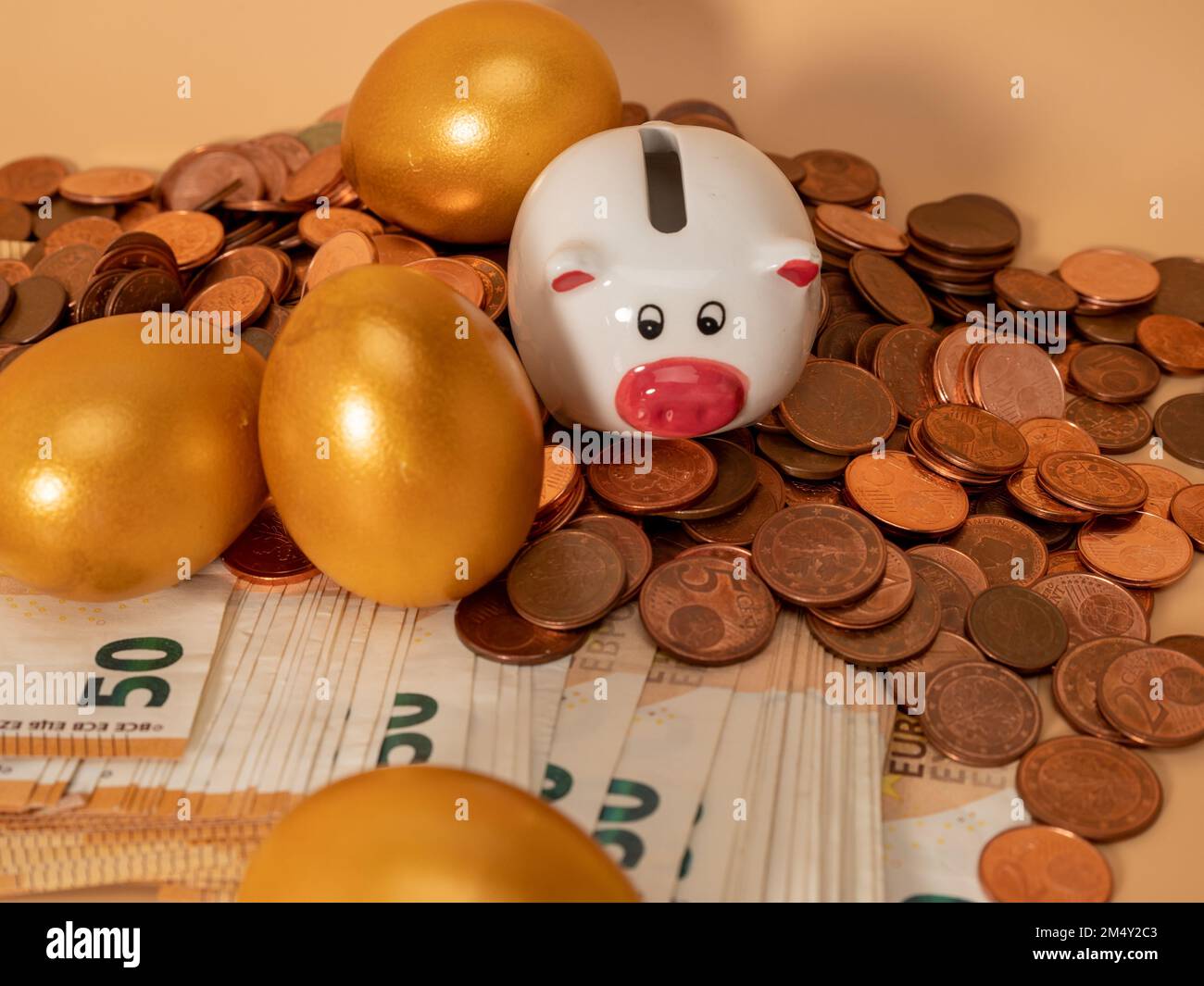 Golden eggs and piggy bank on money. Golden chicken eggs on euro ...