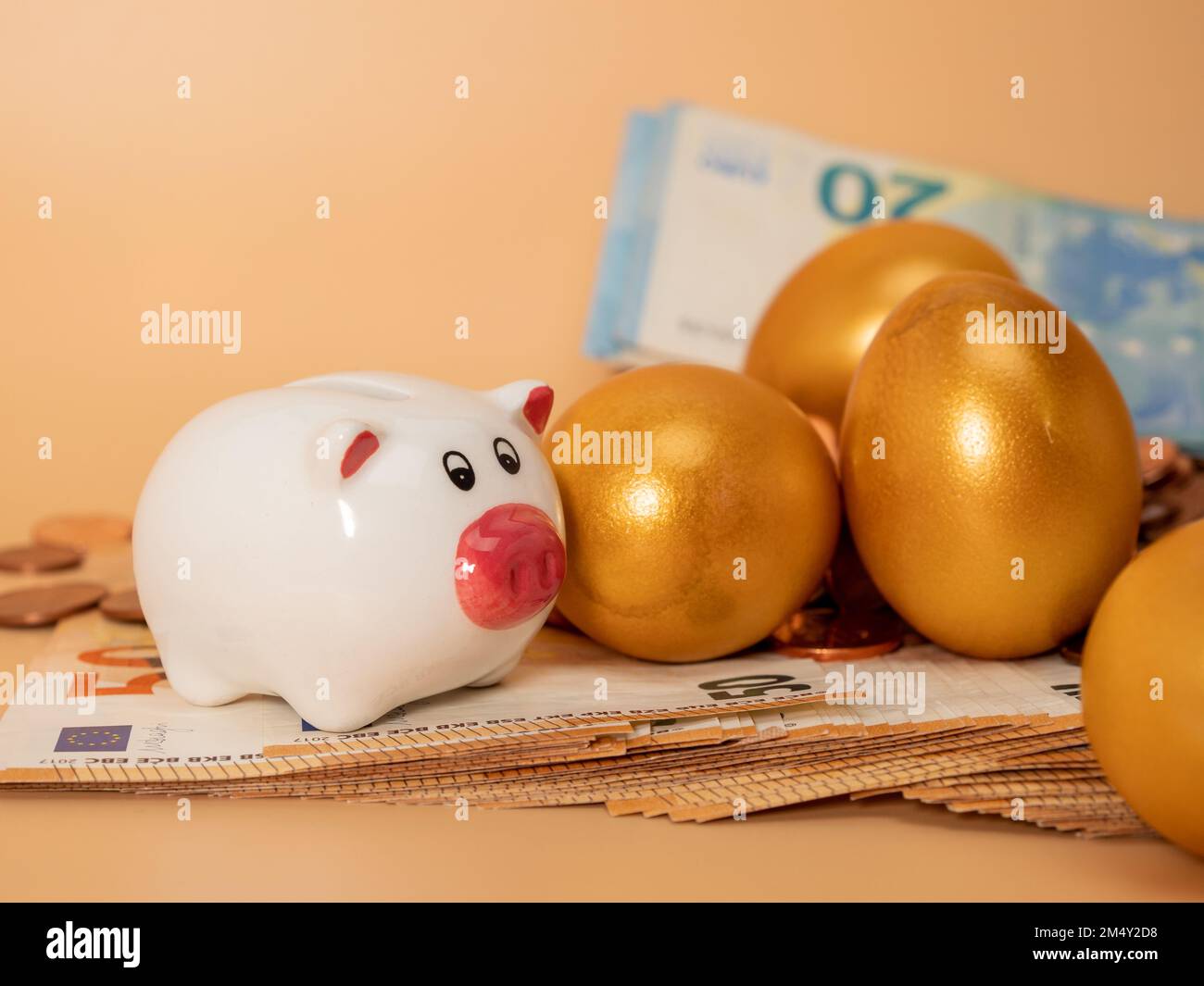Golden eggs and piggy bank on money. Golden chicken eggs on euro ...