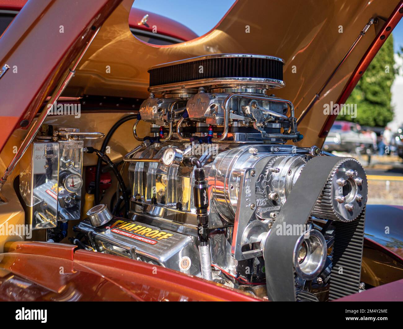 An engine under the red vintage car's open hood at the Classic Car Show ...