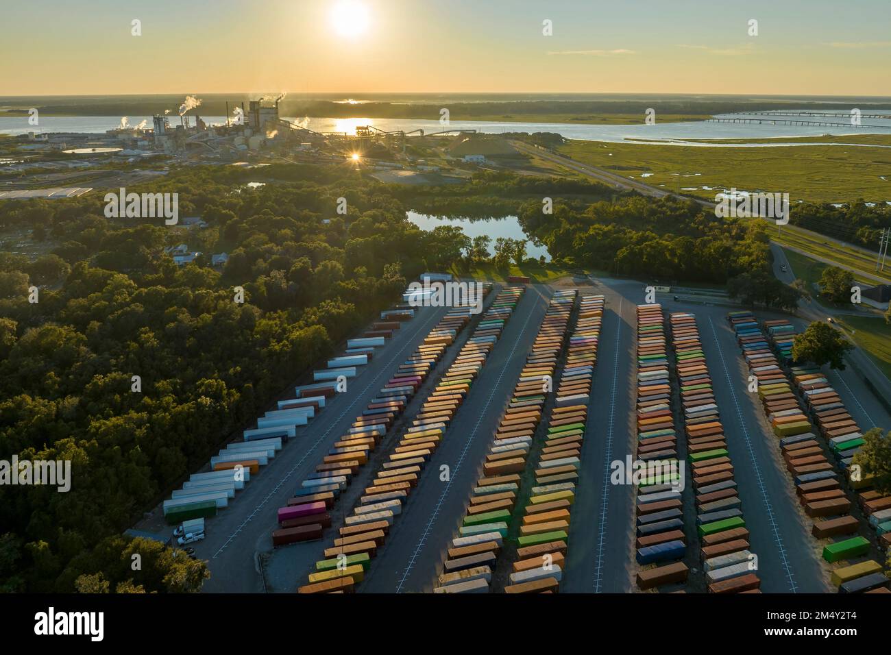 Large cargo container yard with many freight containers and big factory ...