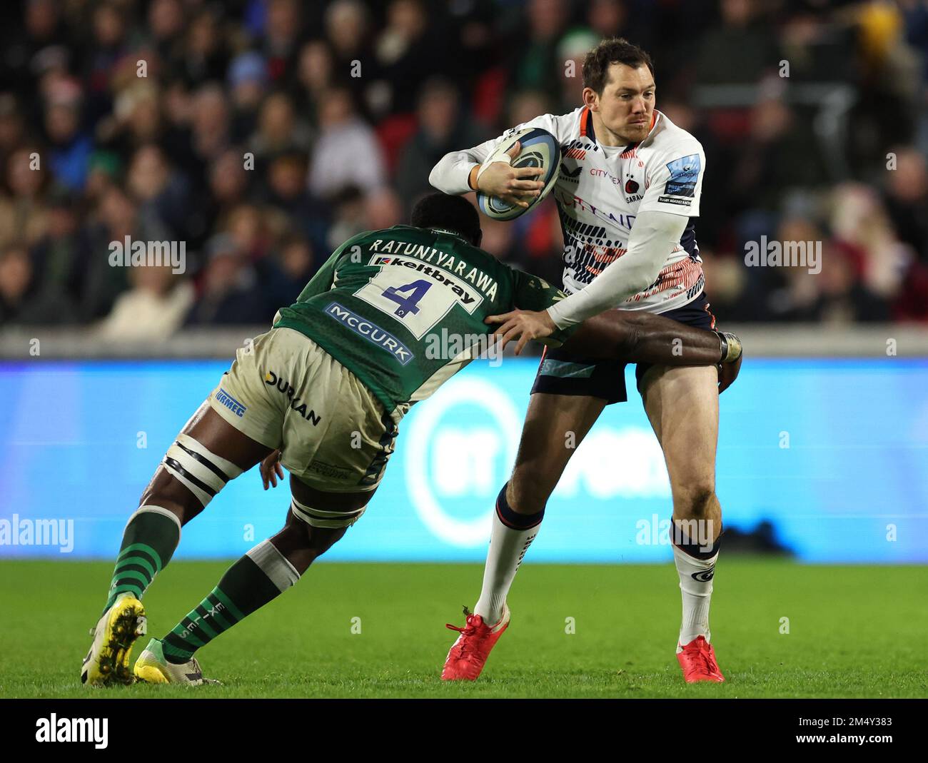 Saracens' Alex Goode (right) tackled by London Irish's Api Ratuniyarawa ...