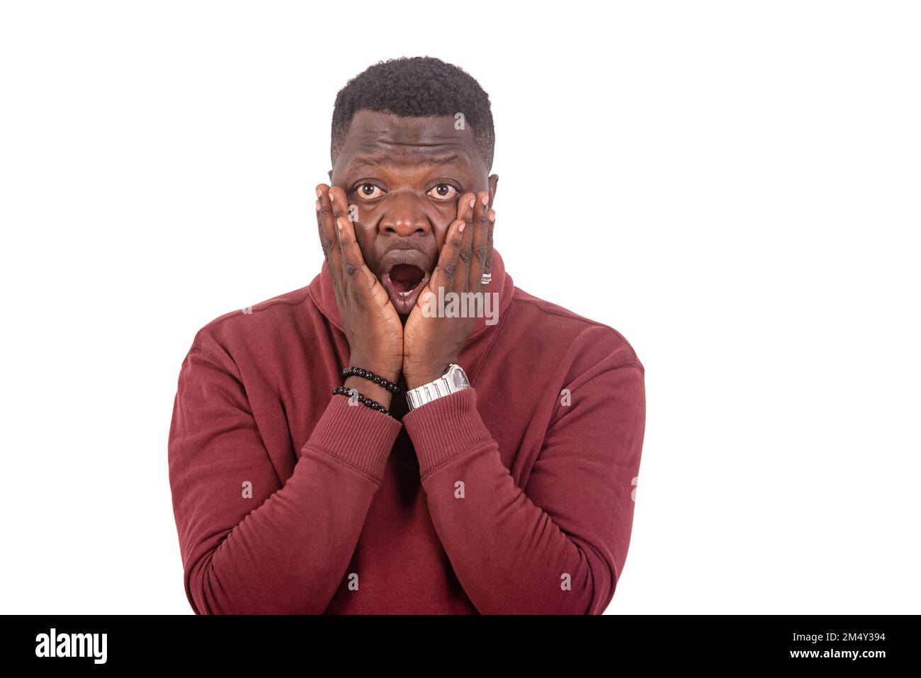 astonished young man with the mouth wide open and hands on cheeks while ...