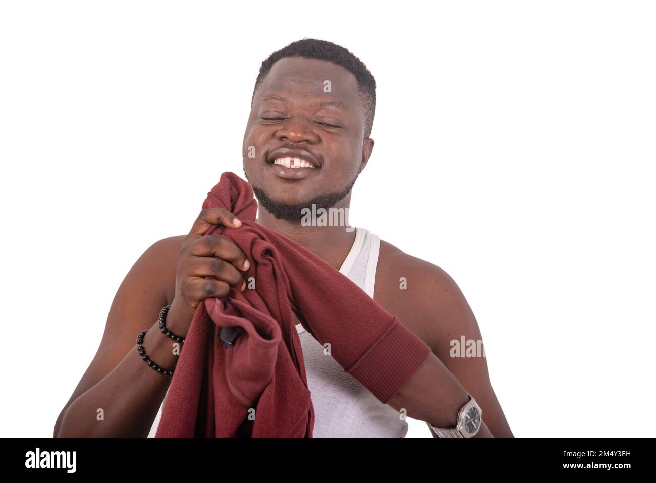 portrait of a handsome young man taking off his t-shirt while smiling ...