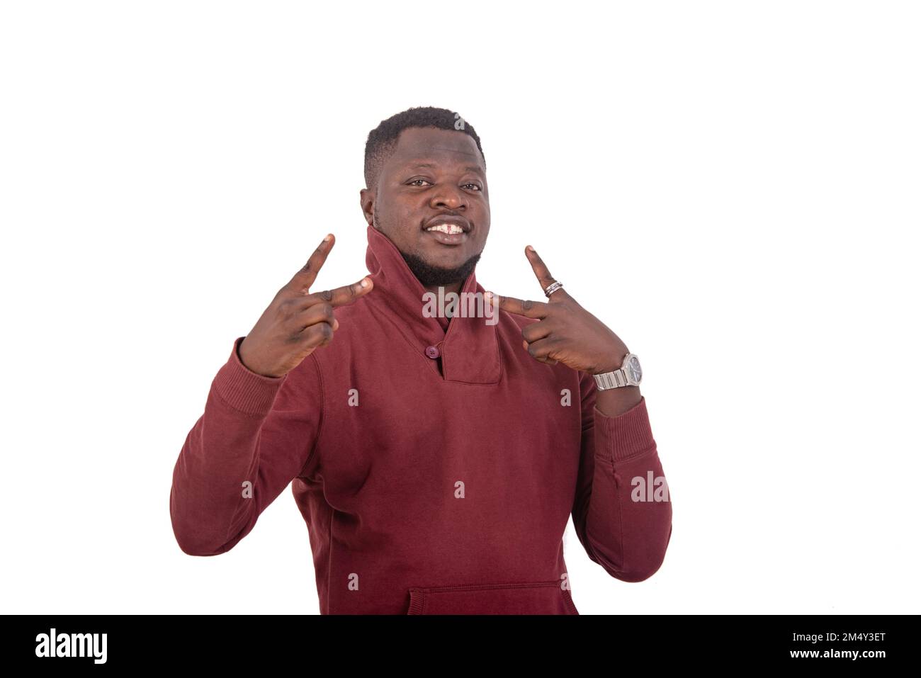 portrait of a handsome young man showing two fingers while smiling at ...
