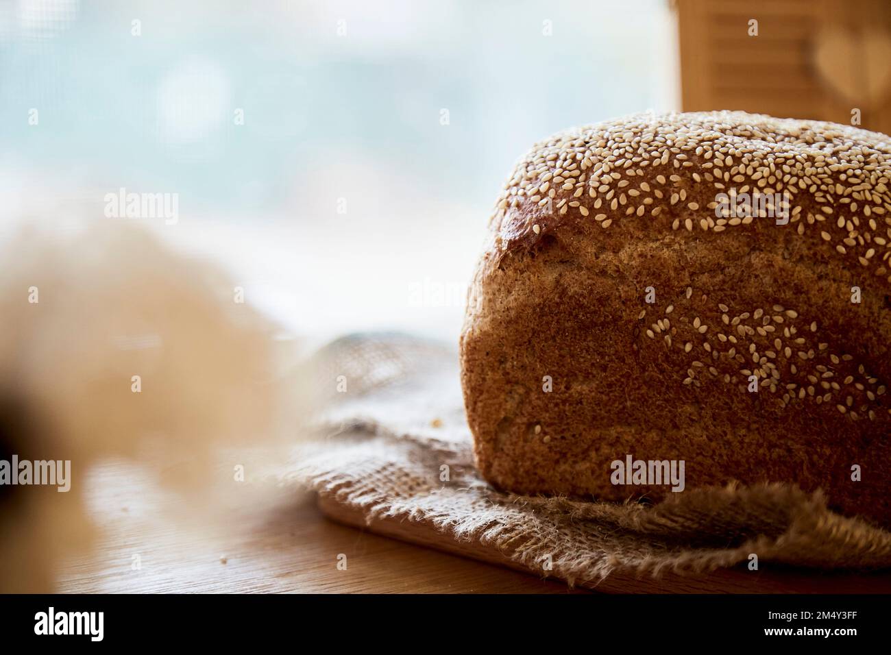 Sourdough unleavened natural sesame bread on wooden cutting board. Loaf ...