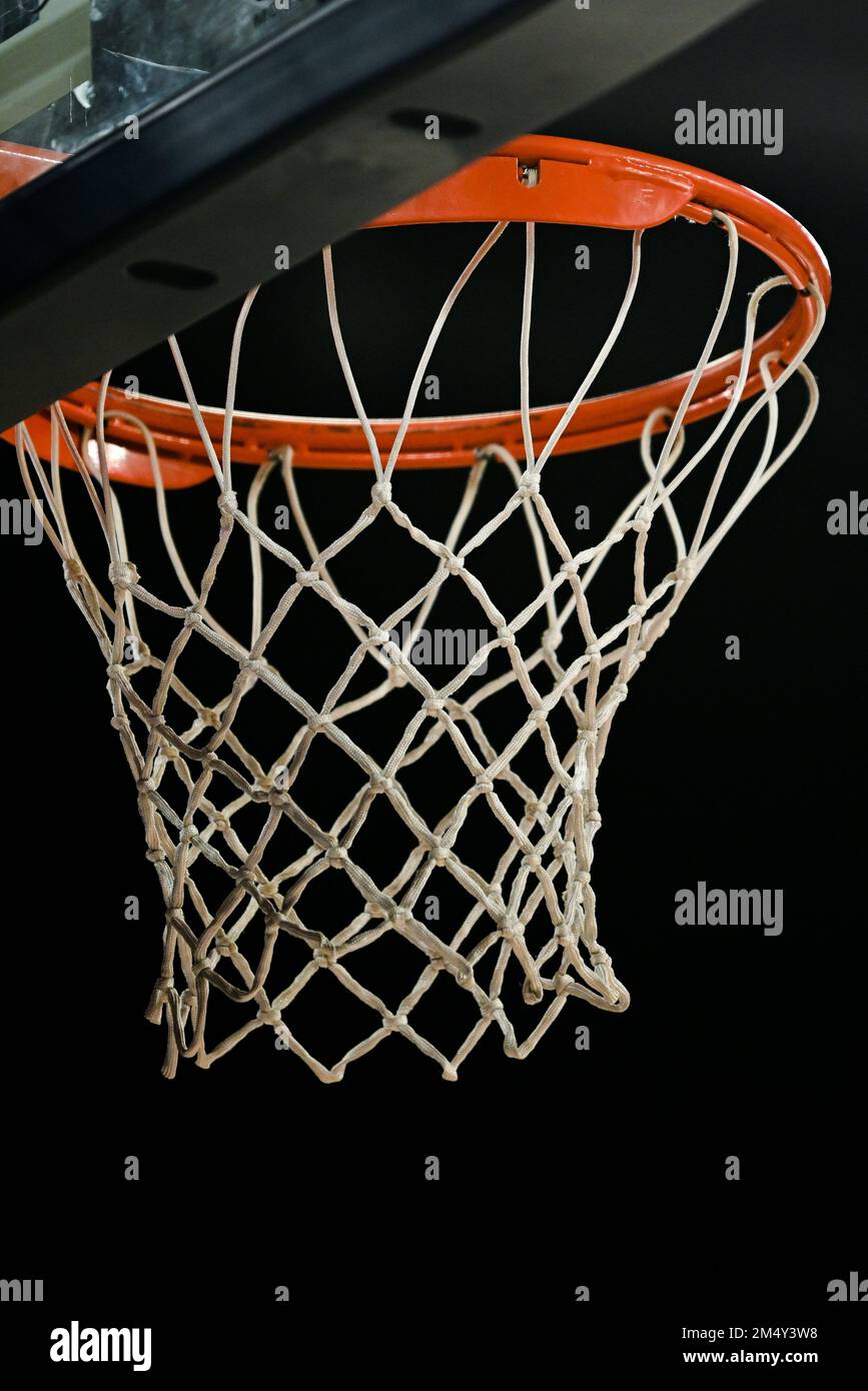 A close-up vertical view of a basketball ring of an indoor stadium ...
