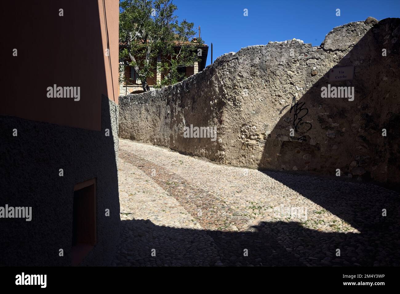 Narrow cobbled street that leads to a covered passageway in an old ...