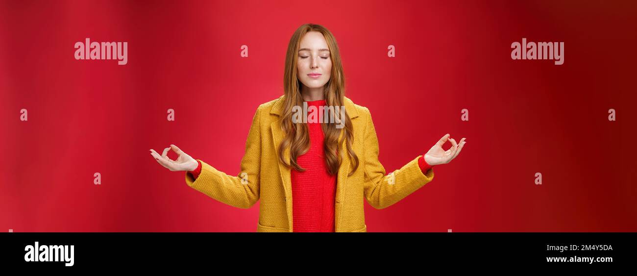 Girl keep calm releasing stress with meditation, posing in yellow coat ...