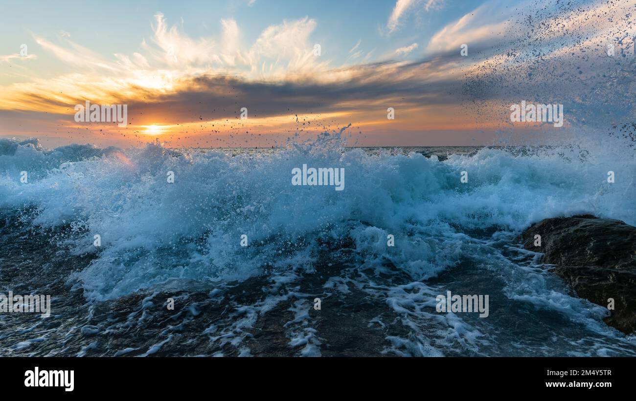 A Sunrise Back Lit Ocean Wave Is Breaking On The Beach Shore In High ...