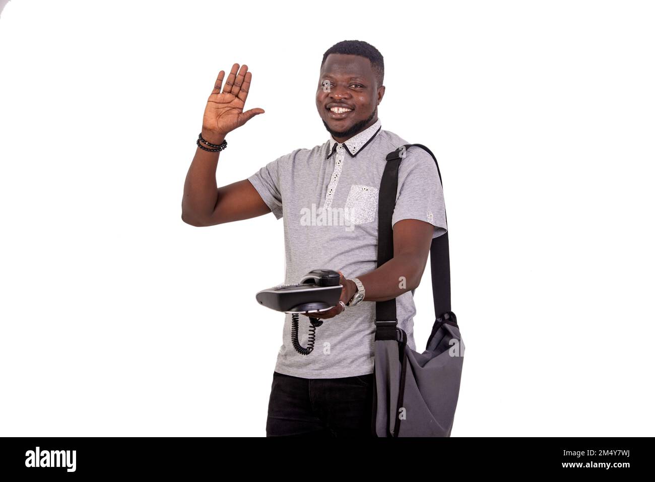 portrait of a young man raising his hand while giving a mobile phone ...