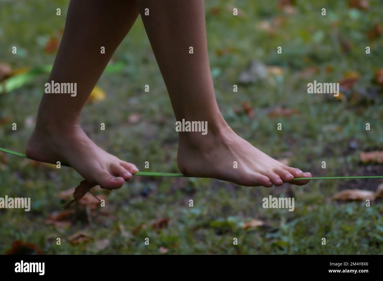 Low section of woman walking on a tightrope Stock Photo - Alamy