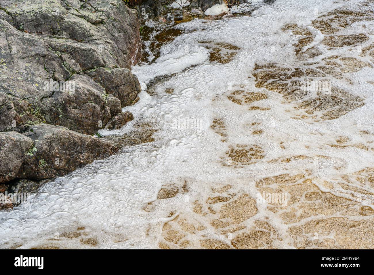 The Sand River with foam and bubbles below a waterfall, Lake Superior ...