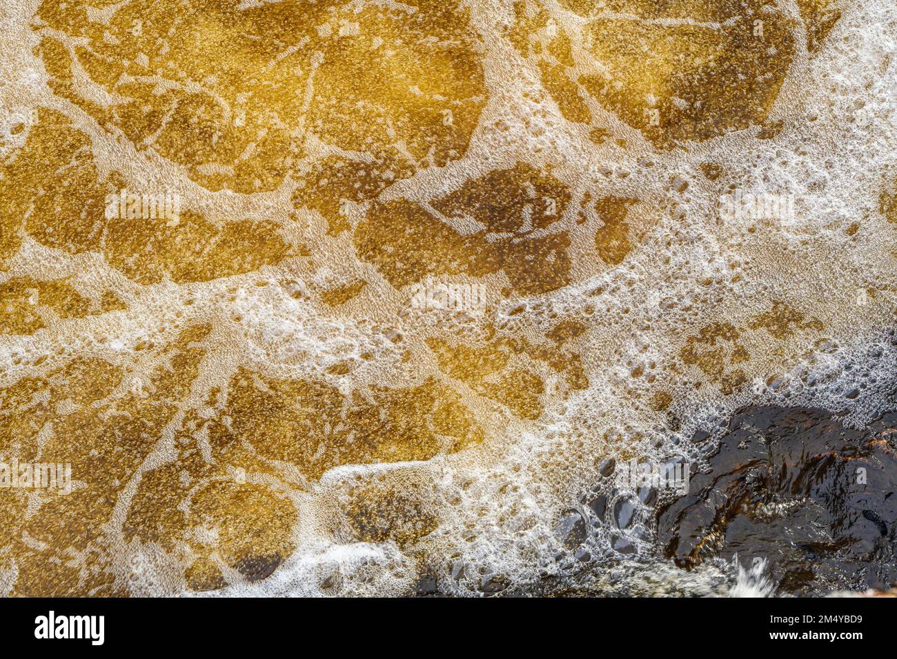 Foam patterns below a waterfall, the Sand River, Lake Superior ...