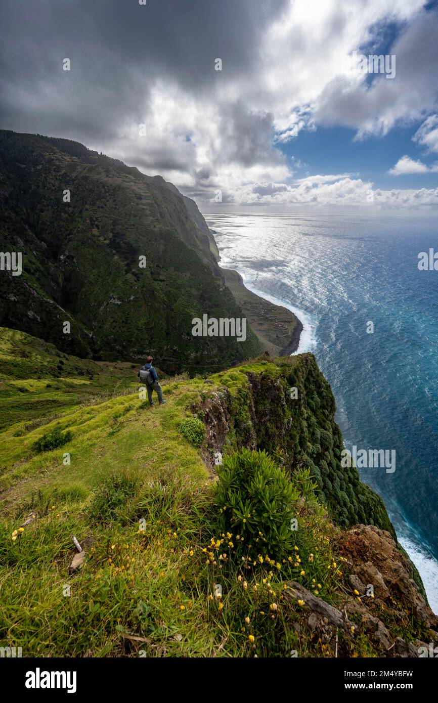 Tourist standing on a cliff, view of cliff with cliffs and sea, coastal ...