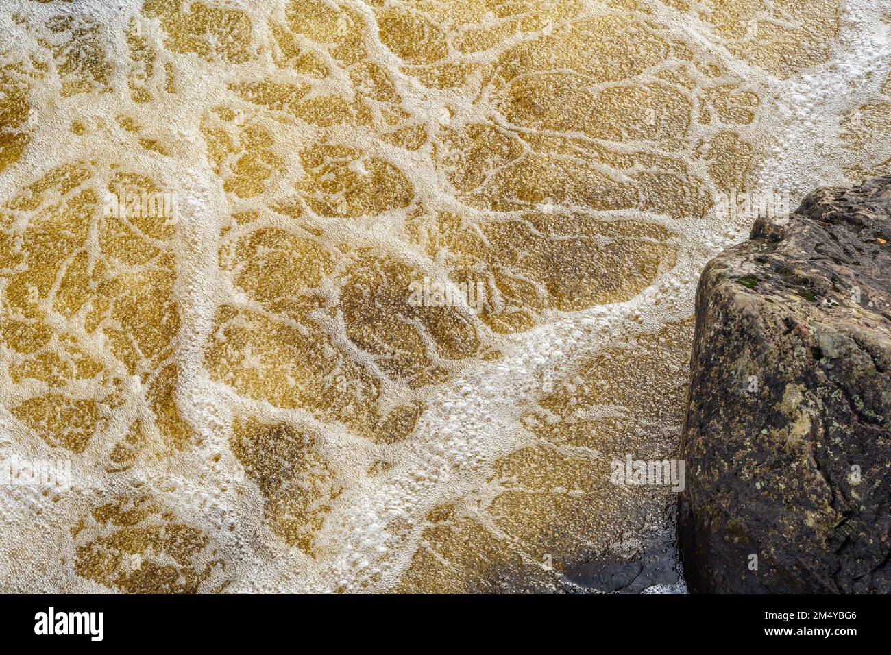 Foam patterns below a waterfall, the Sand River, Lake Superior ...