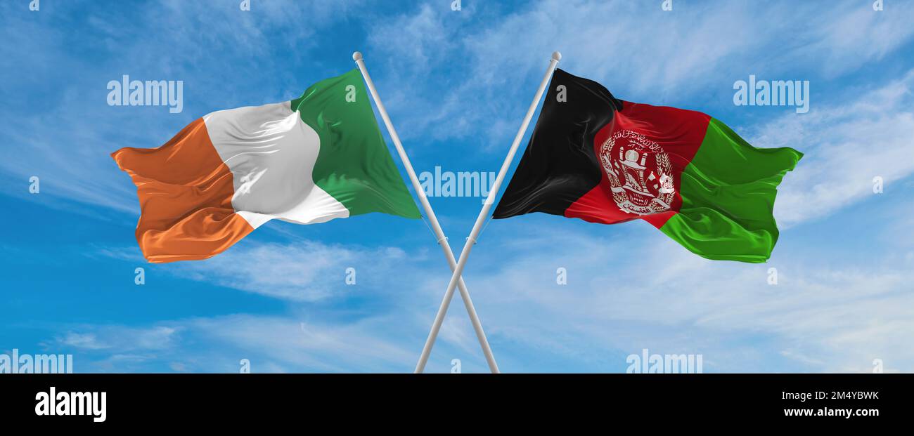 two crossed flags Afghanistan and Ireland waving in wind at cloudy sky. Concept of relationship ...