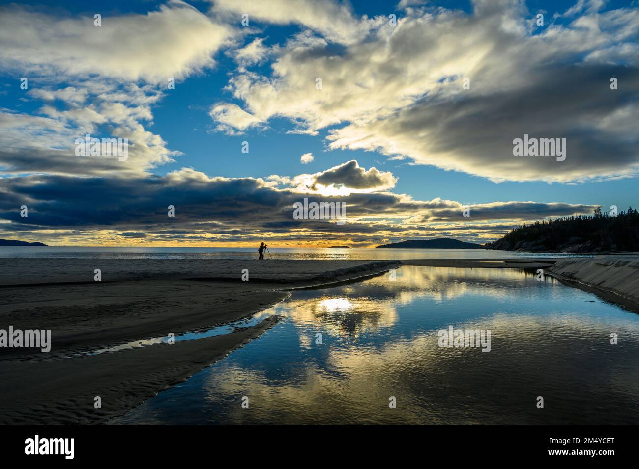 Photographer and evening clouds reflected in unnamed creek at Sand ...