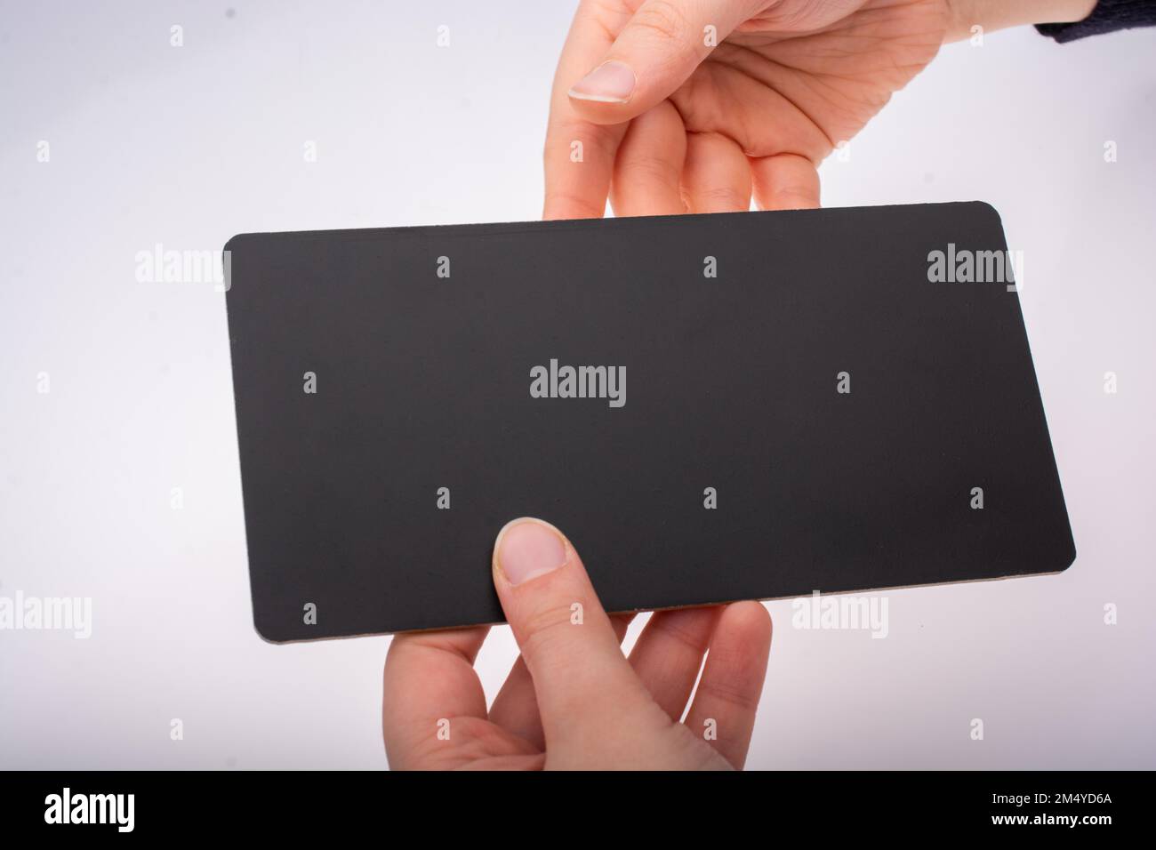 Black speech bubble shaped notice board in hand on white background ...