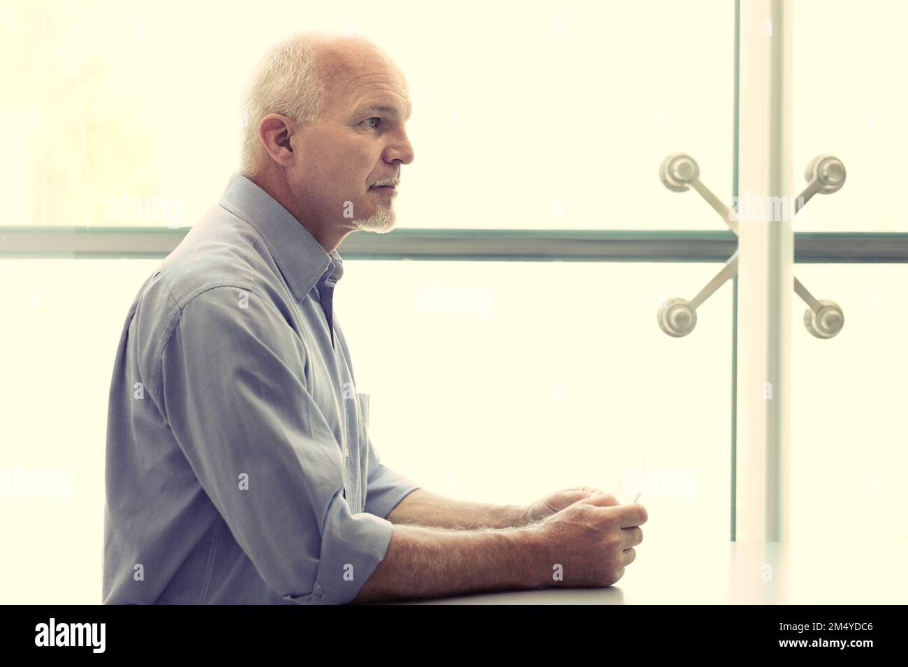 a middle-aged man with a piece of paper in his hand , sitting at a ...