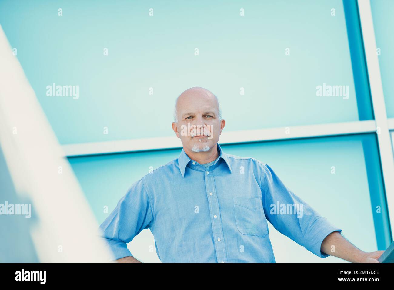 Old man watches from above. He looks far away. He has one hand on his ...