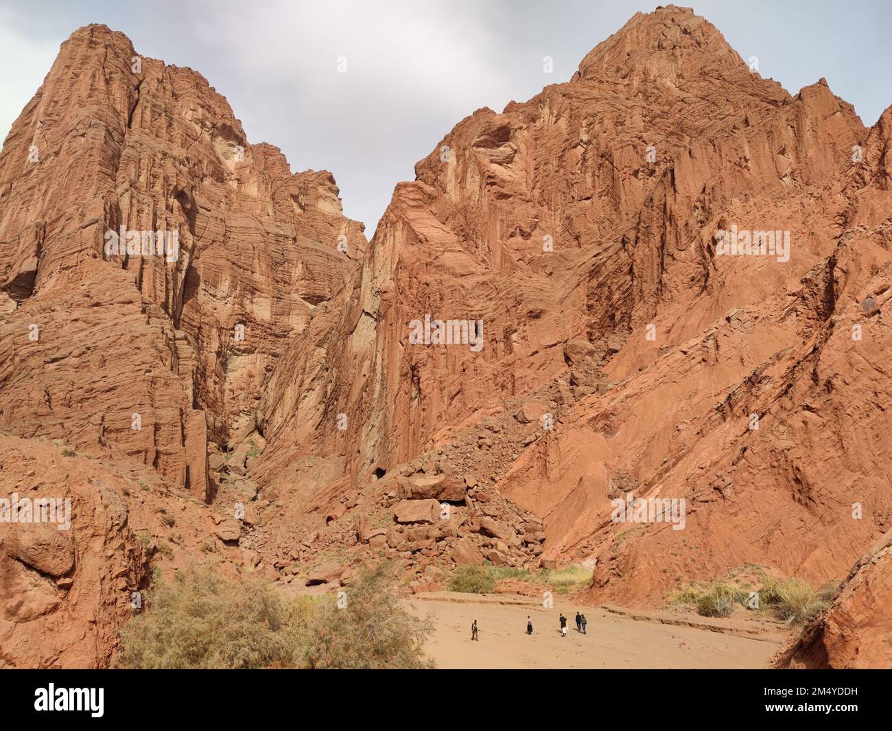 A dry landscape of red rock formations against a blue cloudy sky Stock ...