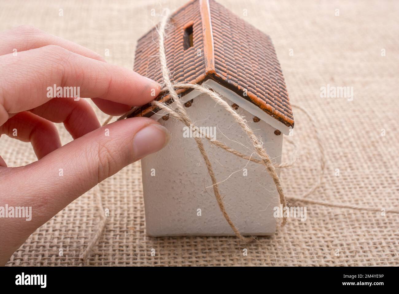 Thread wrapped around a model house on a brown background Stock Photo ...