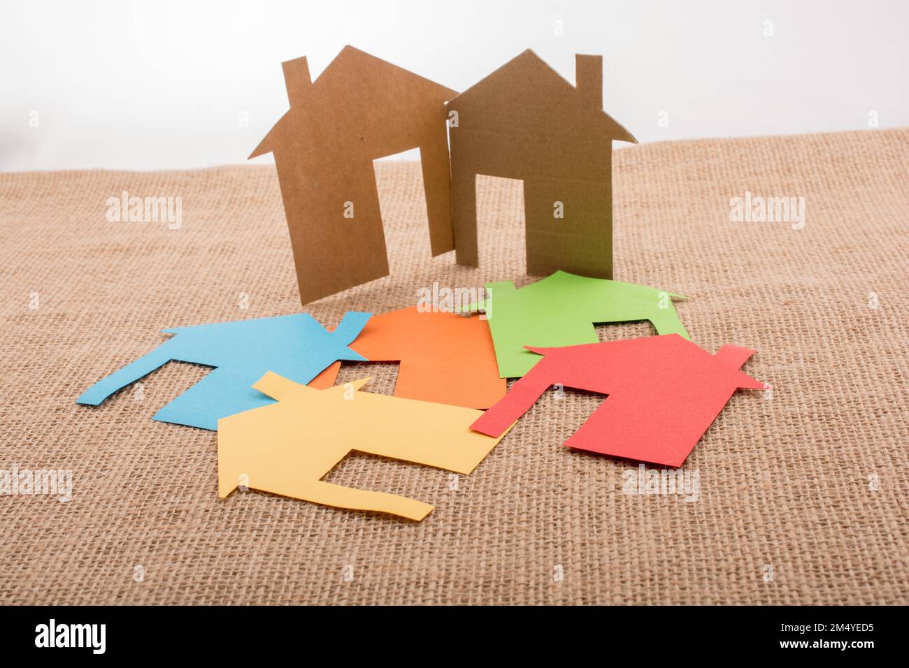 Little house shape cut out of colorful paper on a canvas background ...