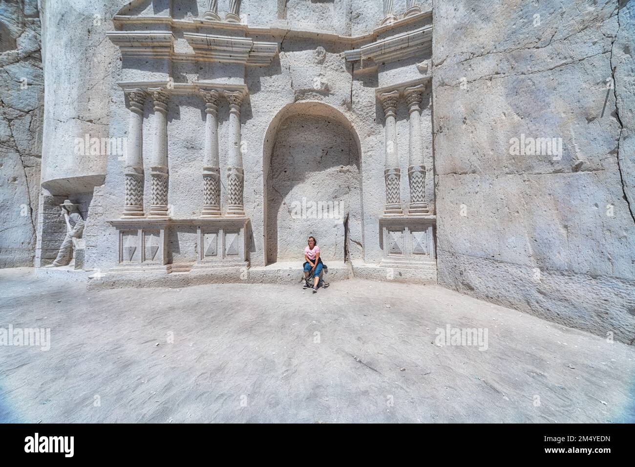 Woman sitting at the famous gate of the ashlar route (ruta del sillar ...