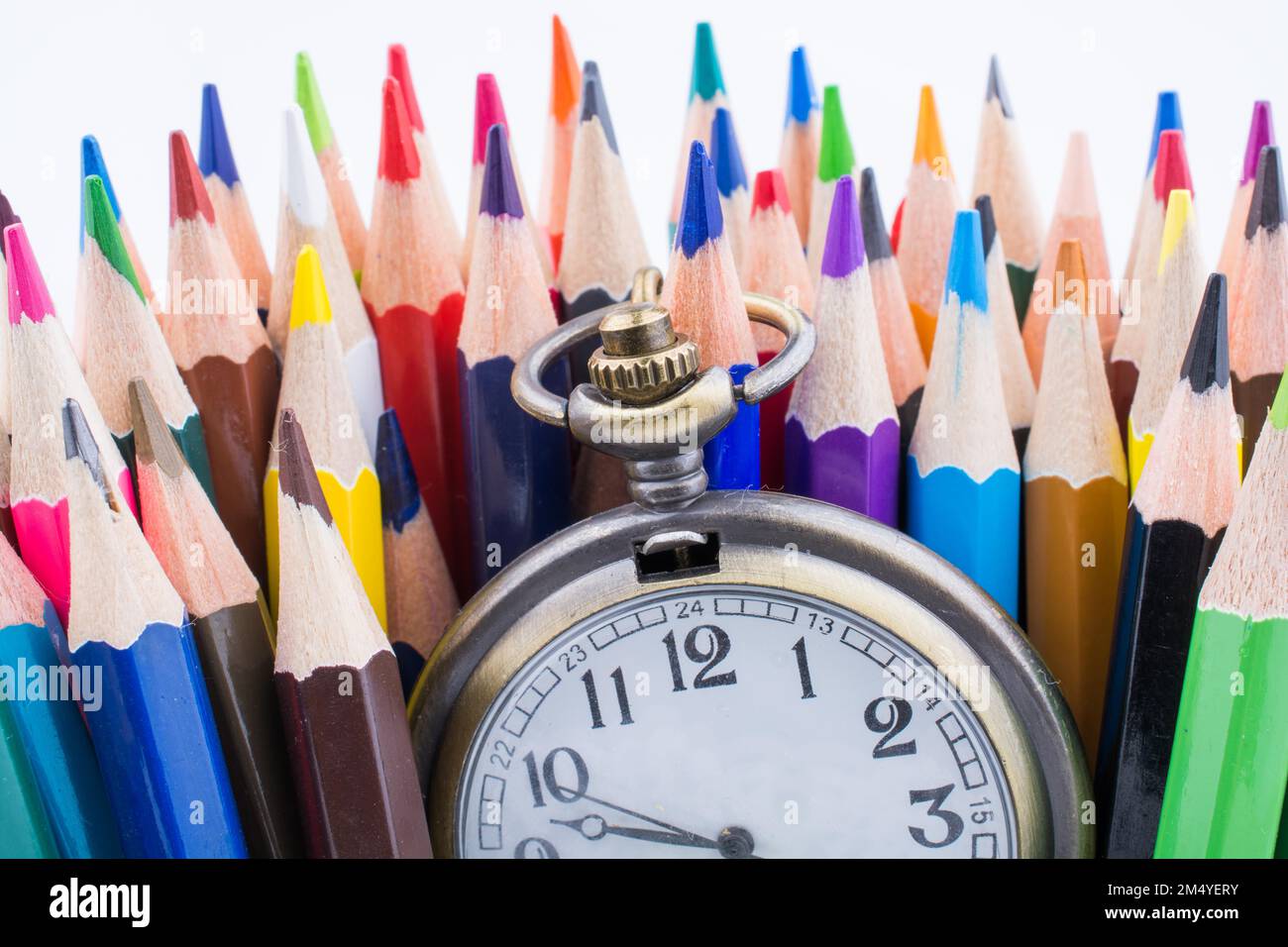 Retro style classic pocket watch and color pencils on white background ...